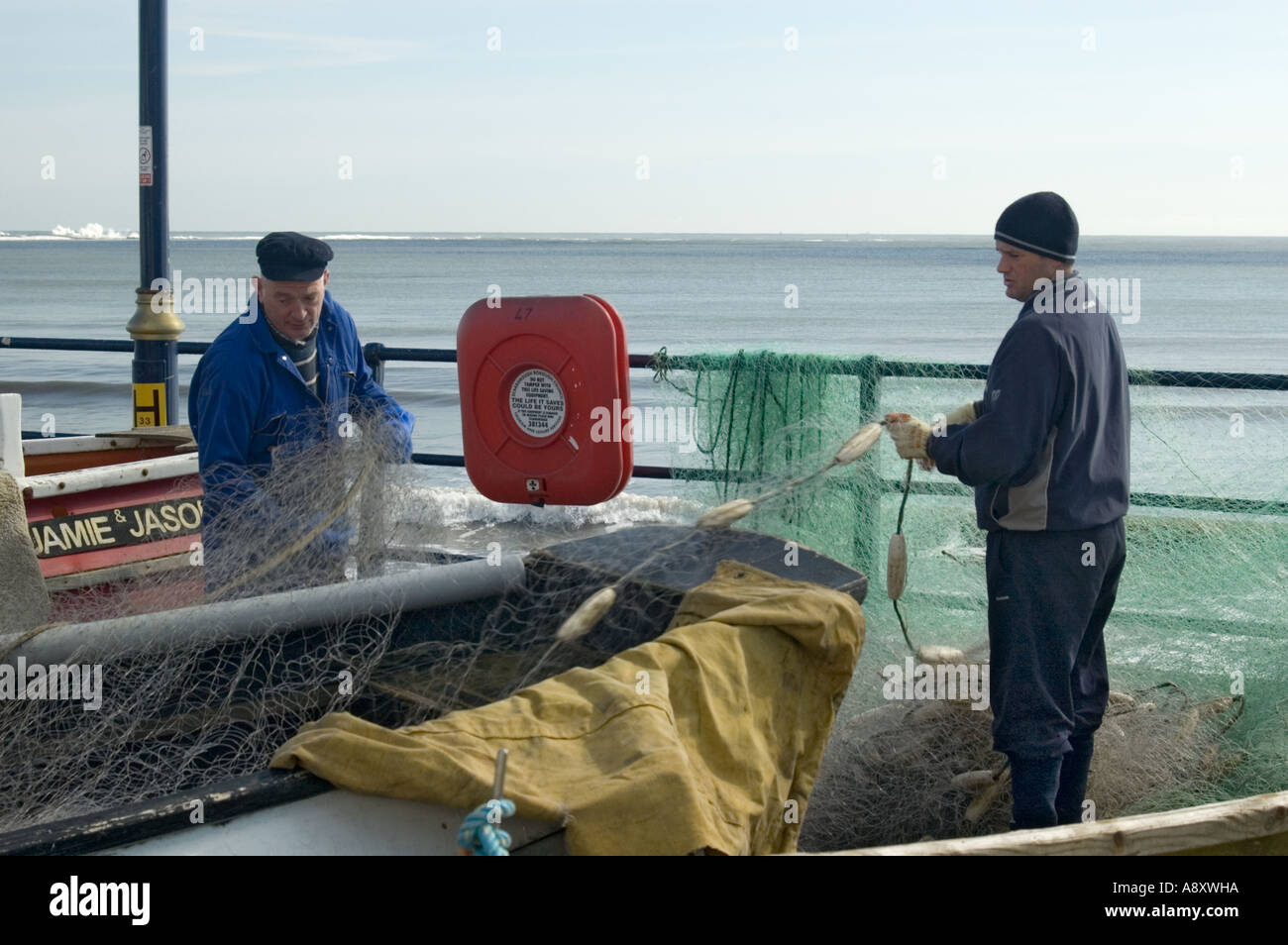 Fishermen repairing their Salmon nets on the Coble landing Filey North ...