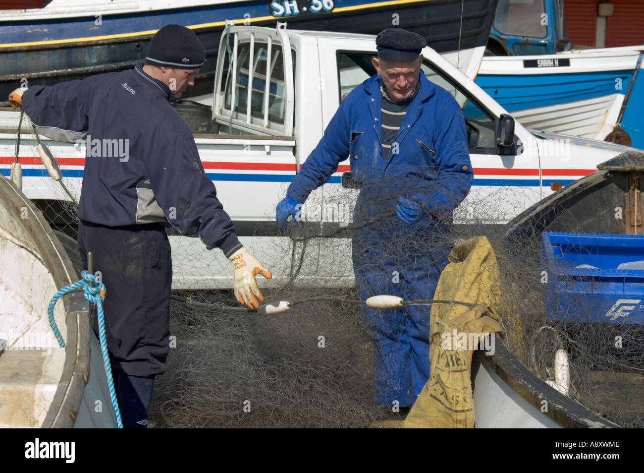 Fishermen repairing their nets on the Coble landing Filey North ...