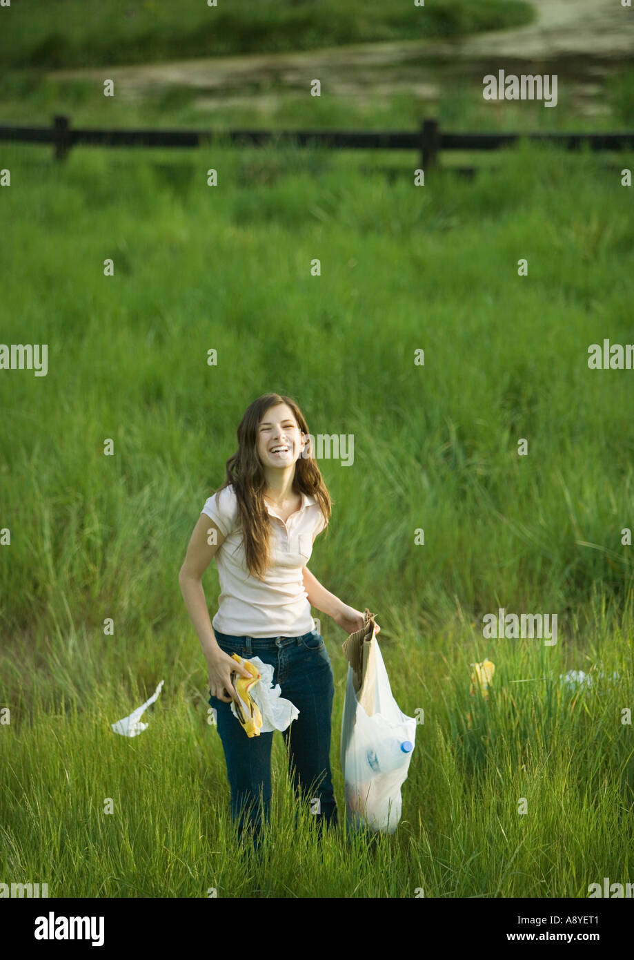 Woman picking up trash in field Stock Photo - Alamy