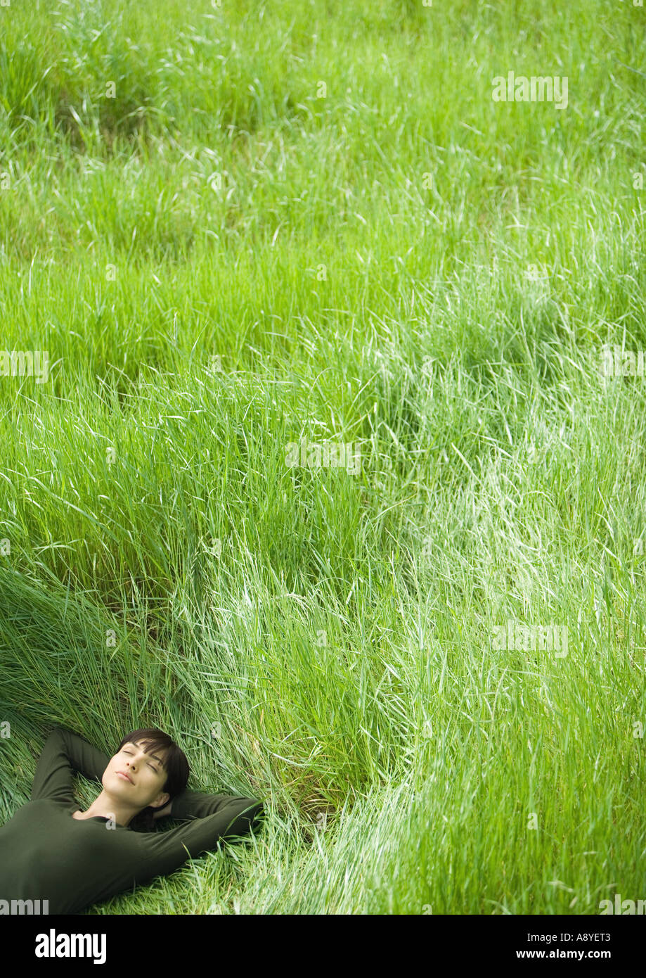Young woman lying in field Stock Photo - Alamy
