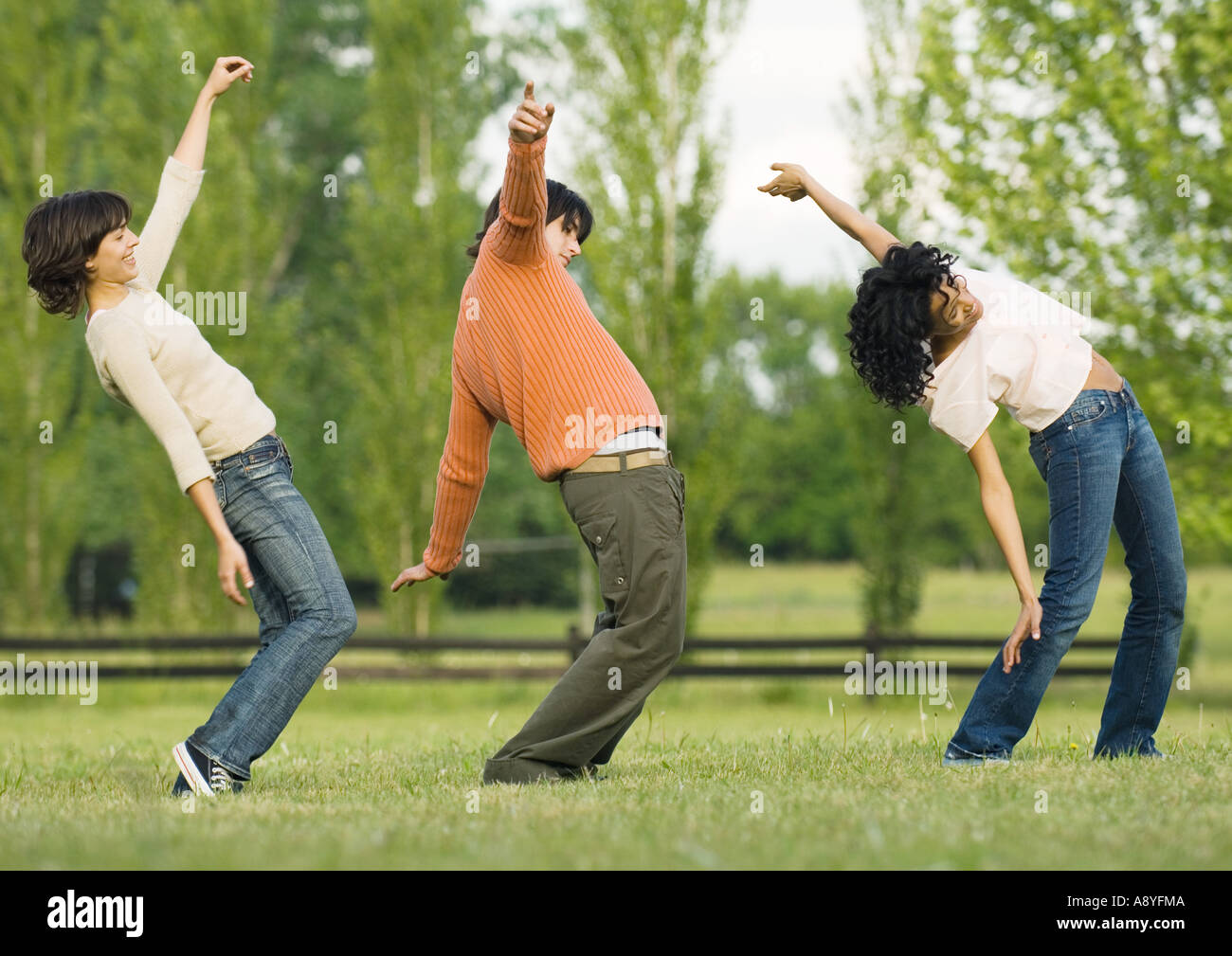 Three friends dancing in a line outdoors Stock Photo - Alamy