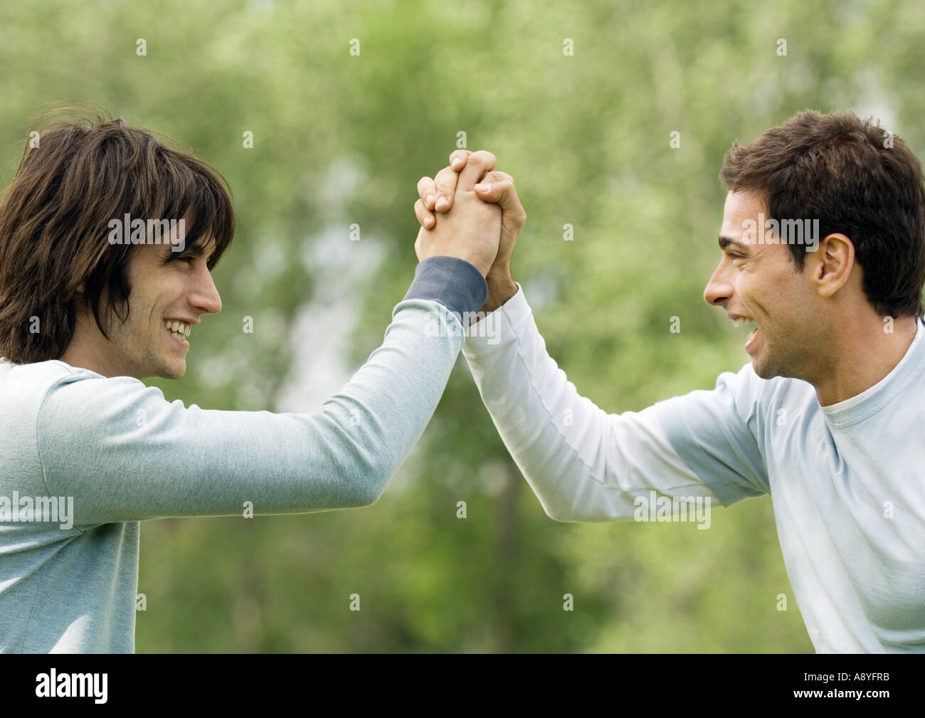 Two young male friends giving each other special handshake Stock Photo ...