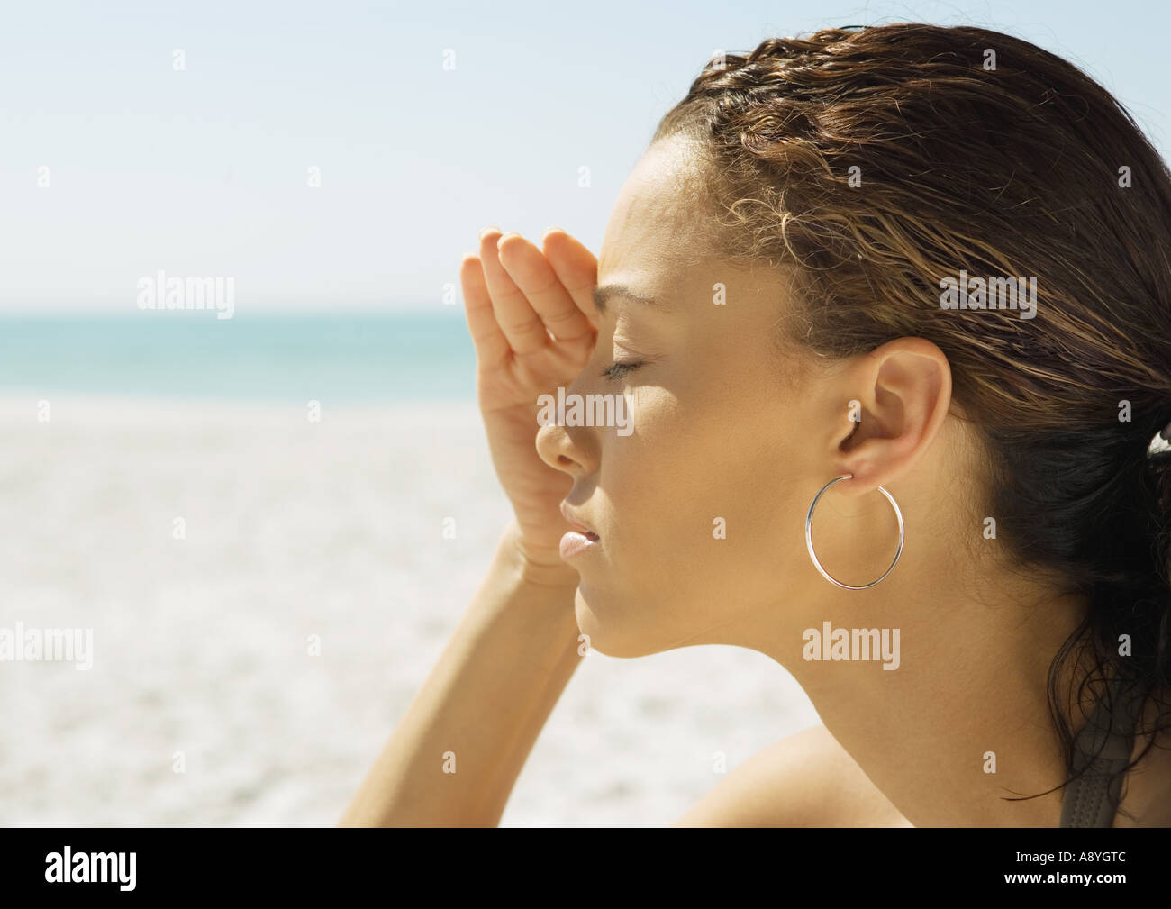 Woman shading eyes on beach, close-up Stock Photo - Alamy