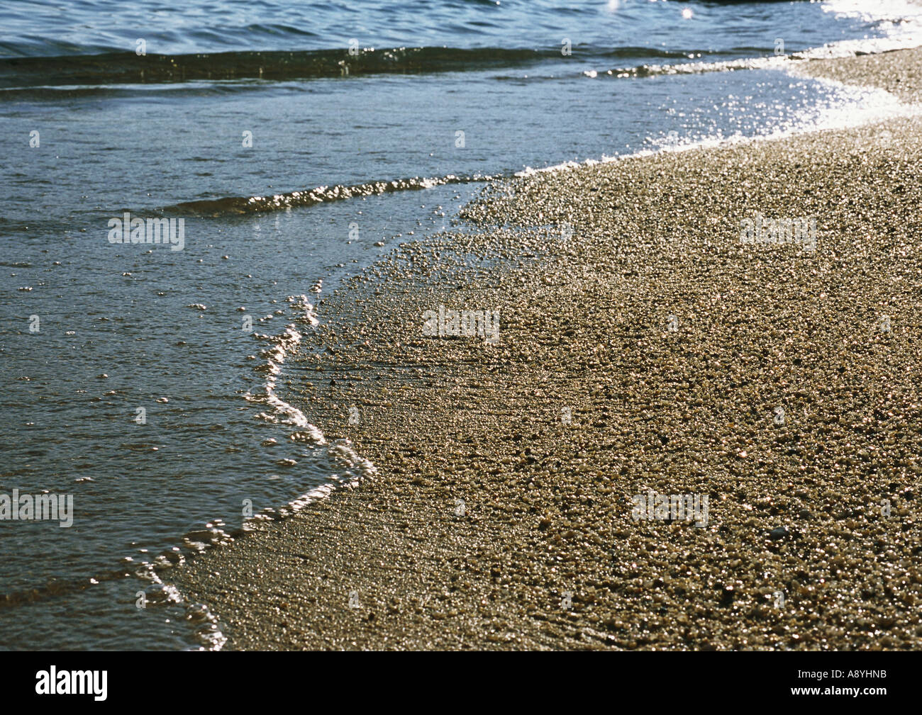 Surf washing up on sand Stock Photo - Alamy