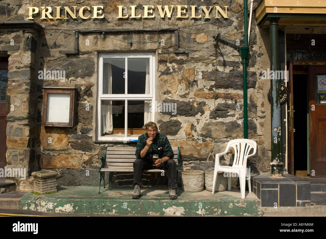 Man drinking beer in sunshine sitting outside Prince Llewelyn pub ...