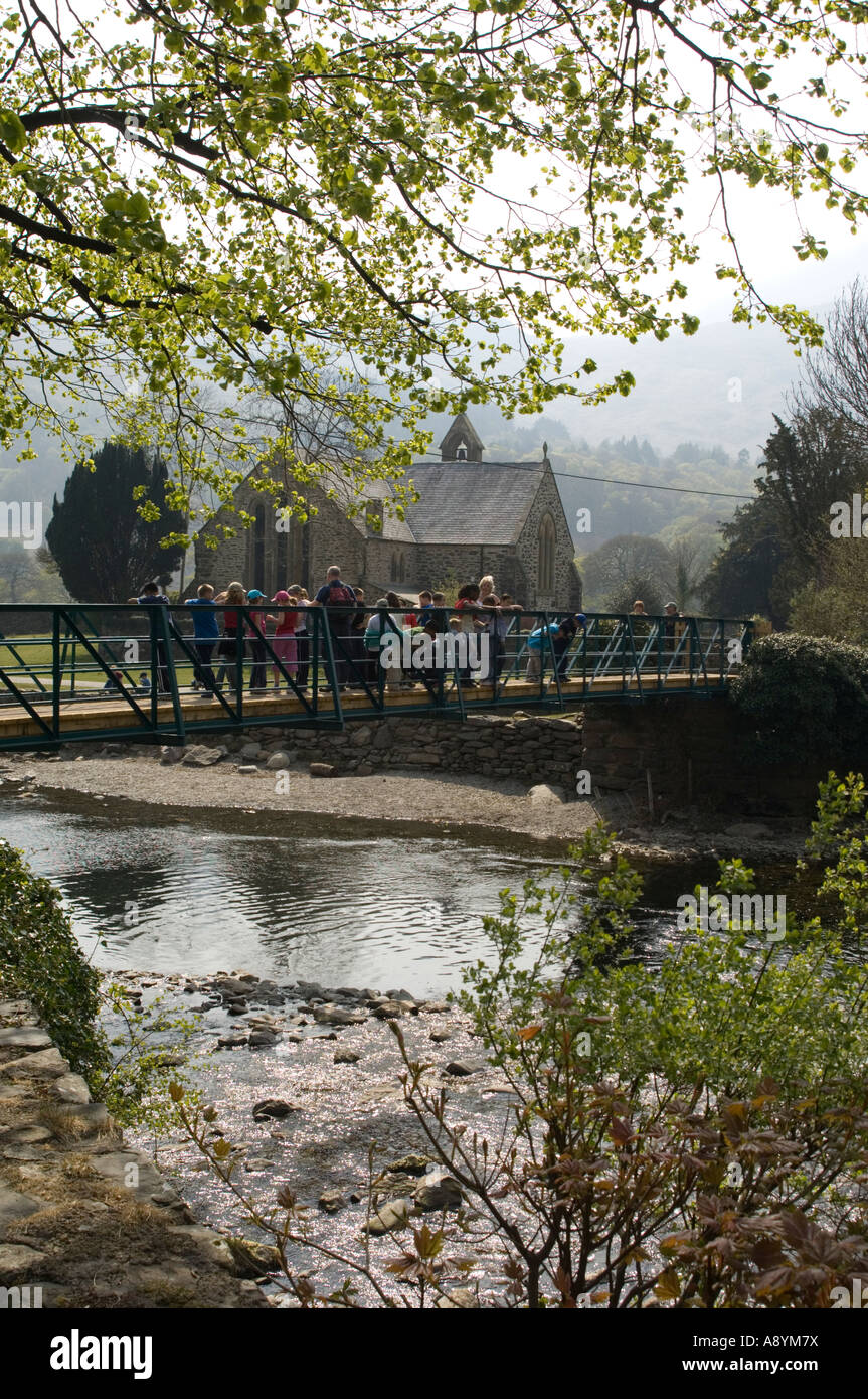 people walking across the Footbridge over the Glaslyn river Beddgelert ...