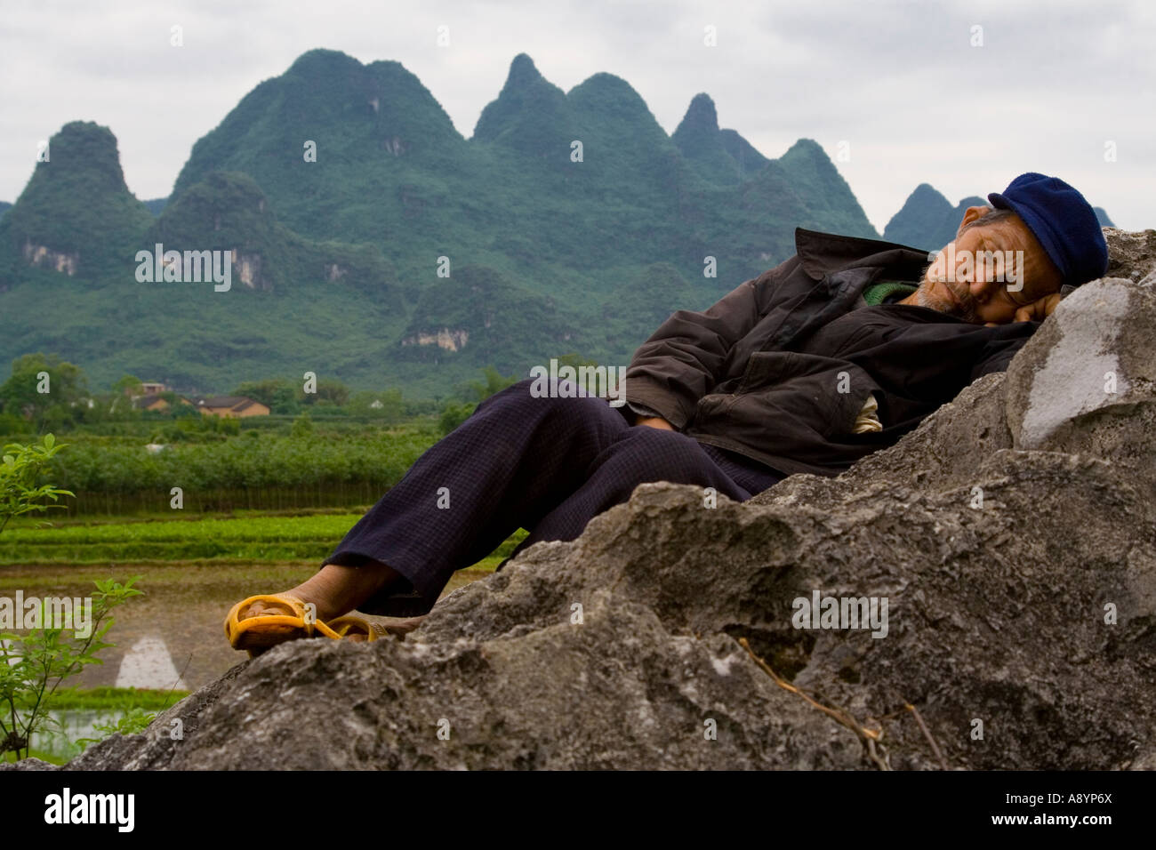 Old Chinese Man Sleeping on Large Limestone Rock near Guilin and ...