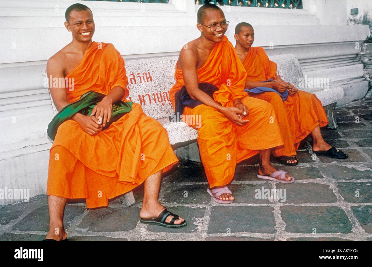 Three young Buddhist student monks seated in a courtyard at Temple of ...