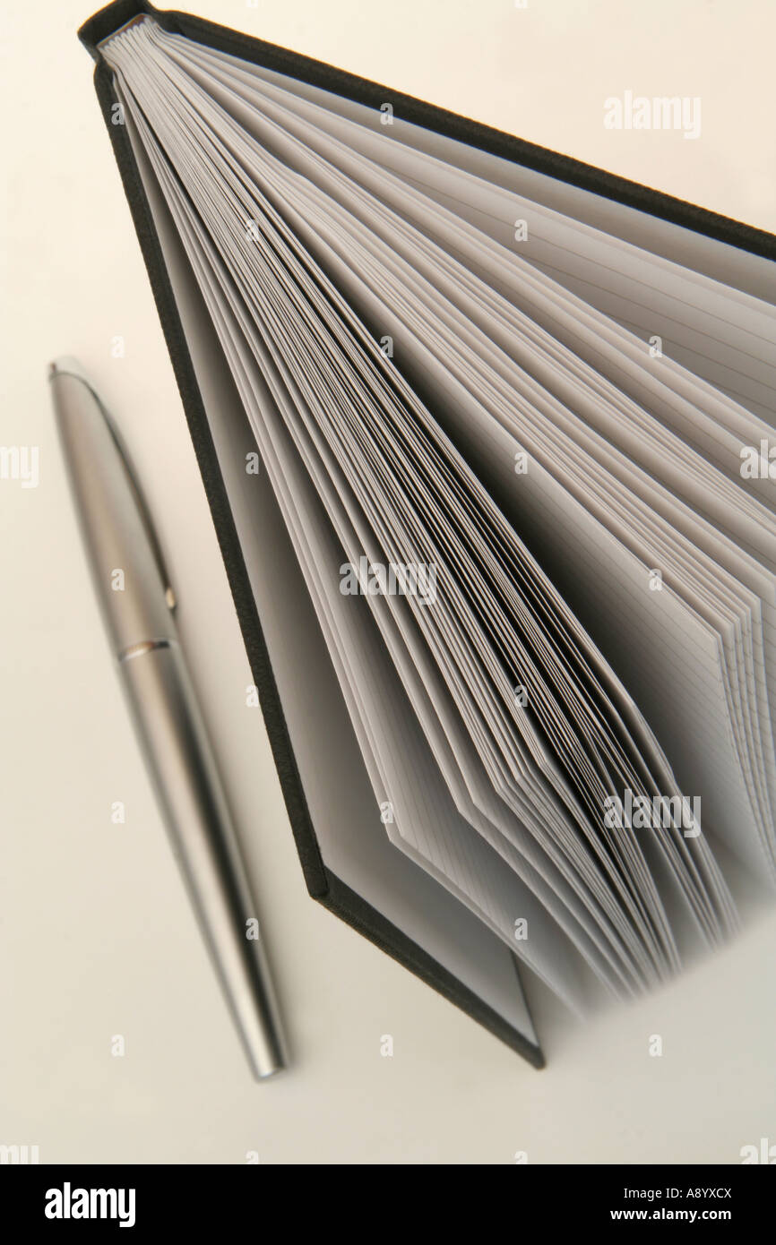 Looking down on a part open notebook standing upright and a pen Stock ...