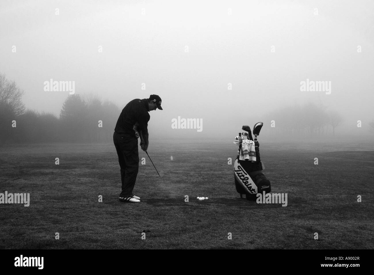 golfer hitting golf ball into the mist Stock Photo - Alamy