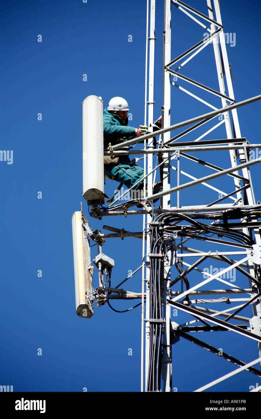 Rigger working on mobile phone antennas on steel lattice tower Stock ...