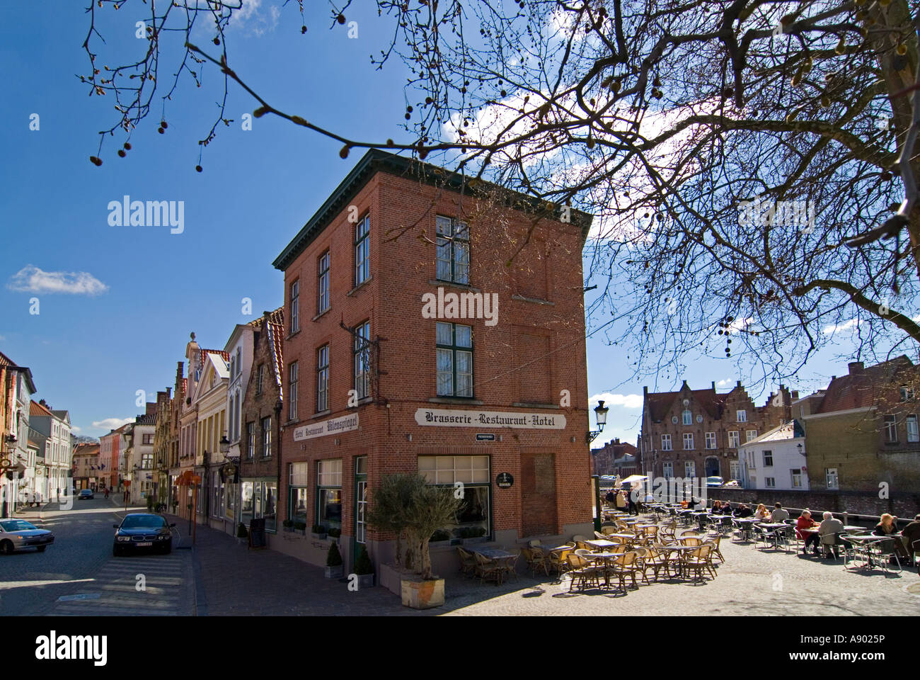Horizontal wide angle of a canal side brasserie with chairs and tables ...