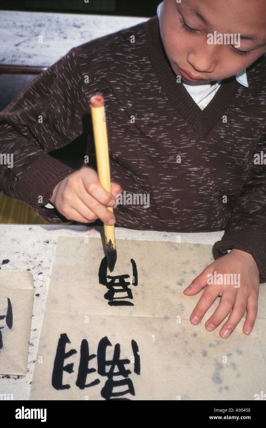 Boy writing Chinese calligraphy using brush Shanghai China Stock Photo ...