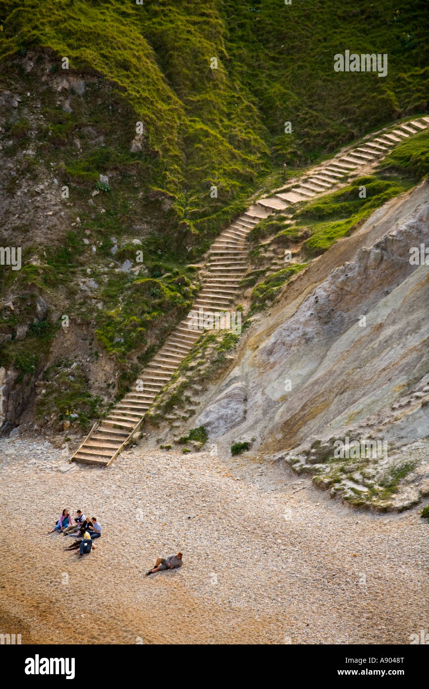 visitors relax on the beach at Man O War Bay behind Durdle Door Dorset ...