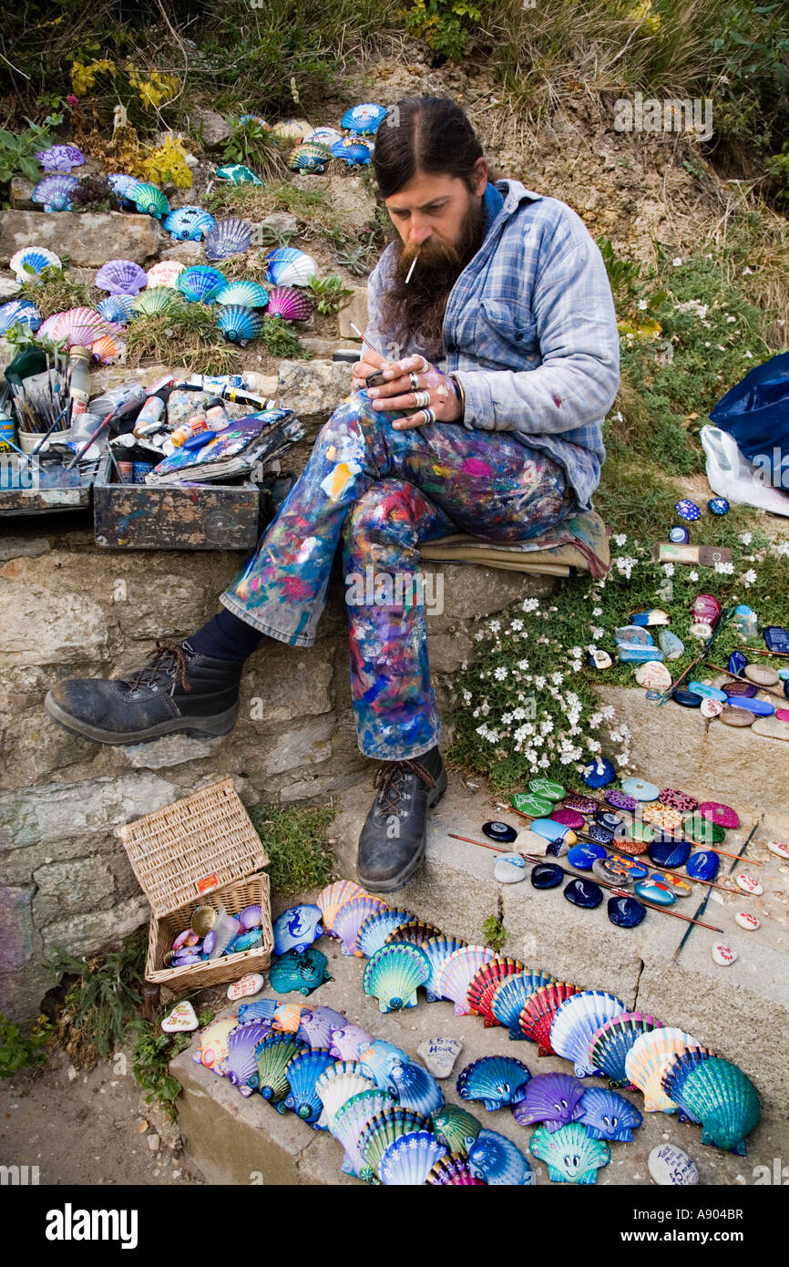 Local craft person painting and selling his souvenir shells and stones ...