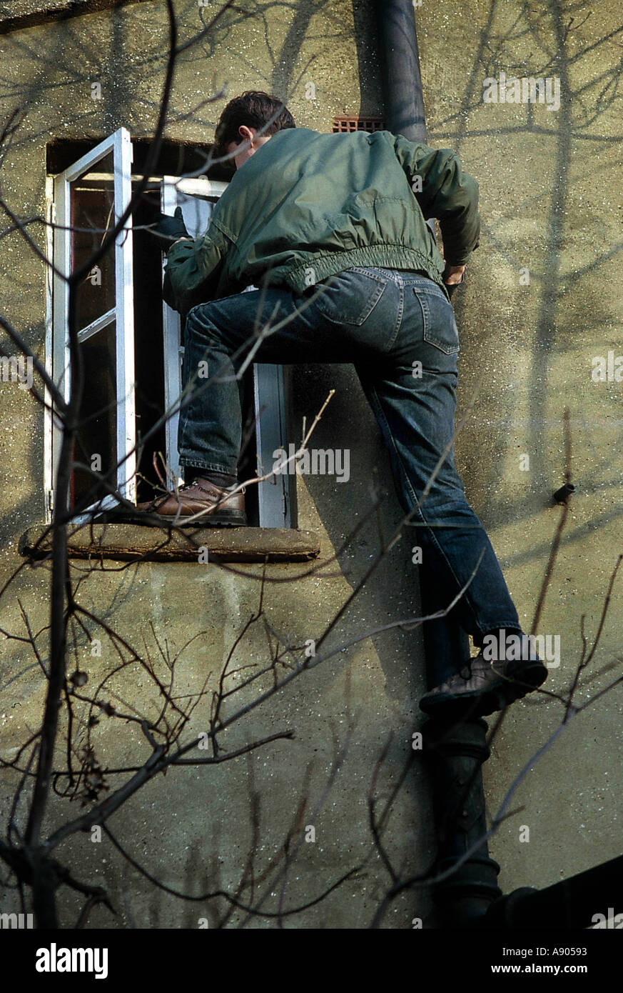 Burglar climbing into an open window Stock Photo - Alamy