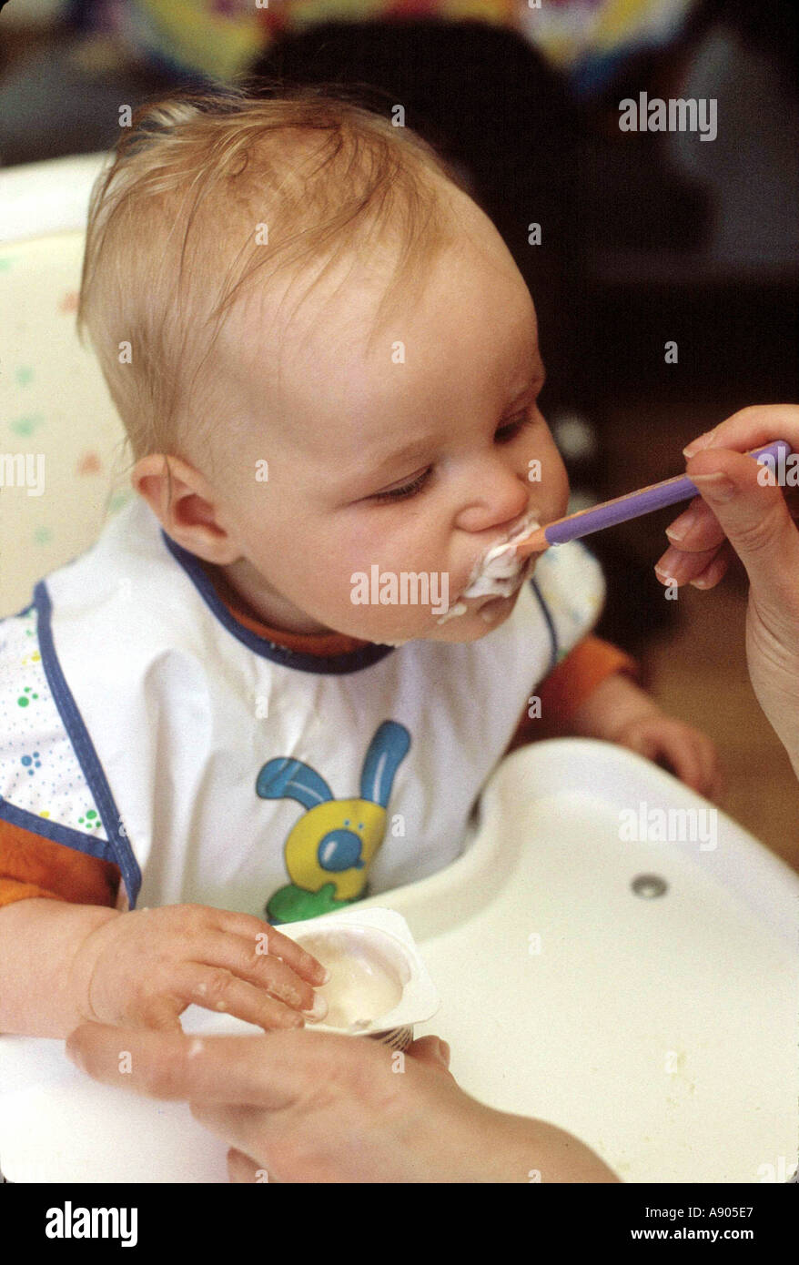 baby being spoon fed in highchair Stock Photo - Alamy