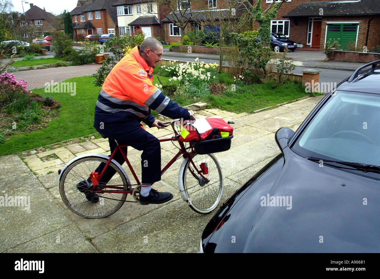 Postman on bicycle delivering mail Stock Photo - Alamy