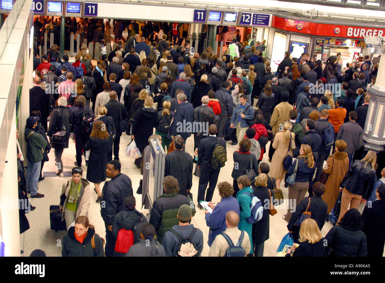 Commuters waiting for trains at busy station Stock Photo - Alamy