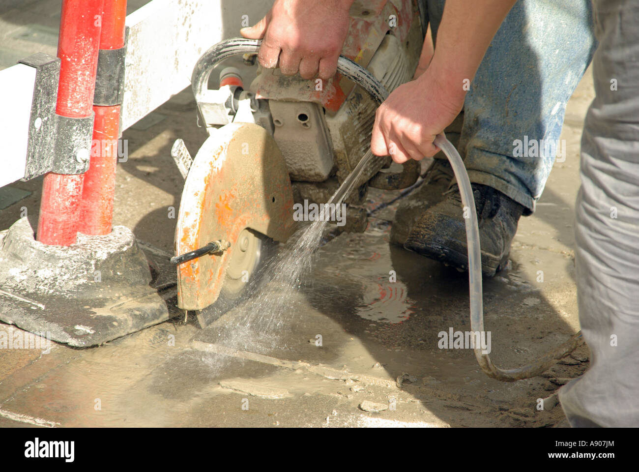 Pavement repair relaying work in progress two workmen using disc cutter ...