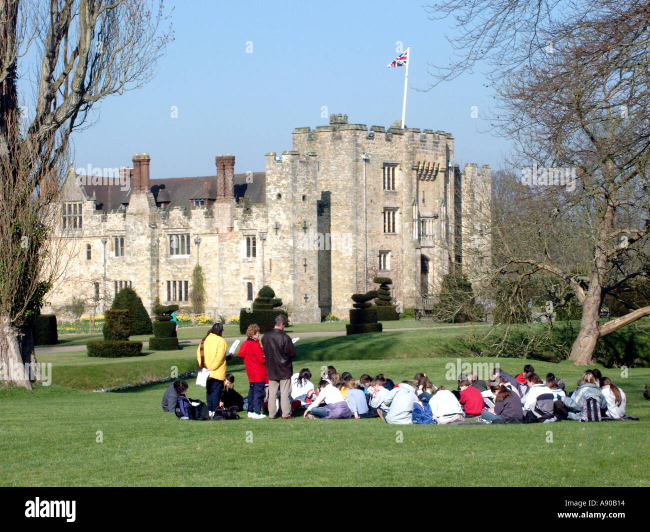 Hever Castle school children group sitting on lawn educational visit ...