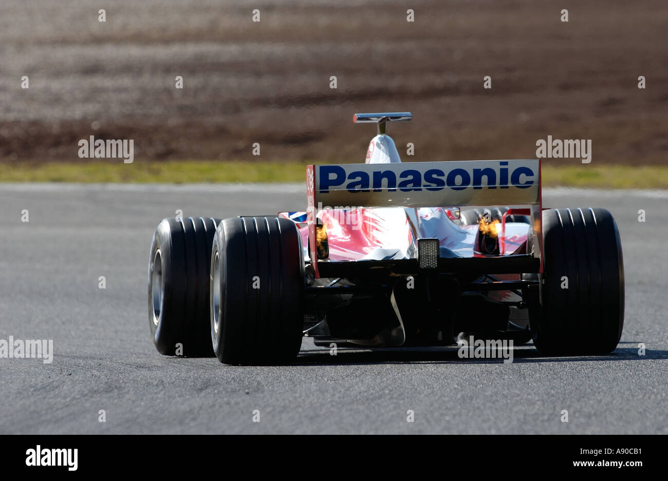 Formula One racing car speeding down the track, spitting fire from the ...