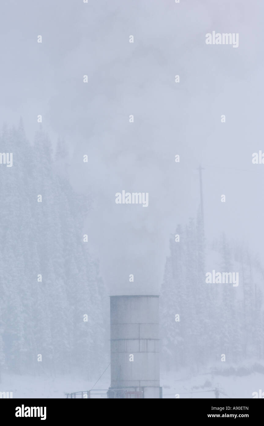 A vertical image of a smoke stack at a coal processing plant in a snow ...