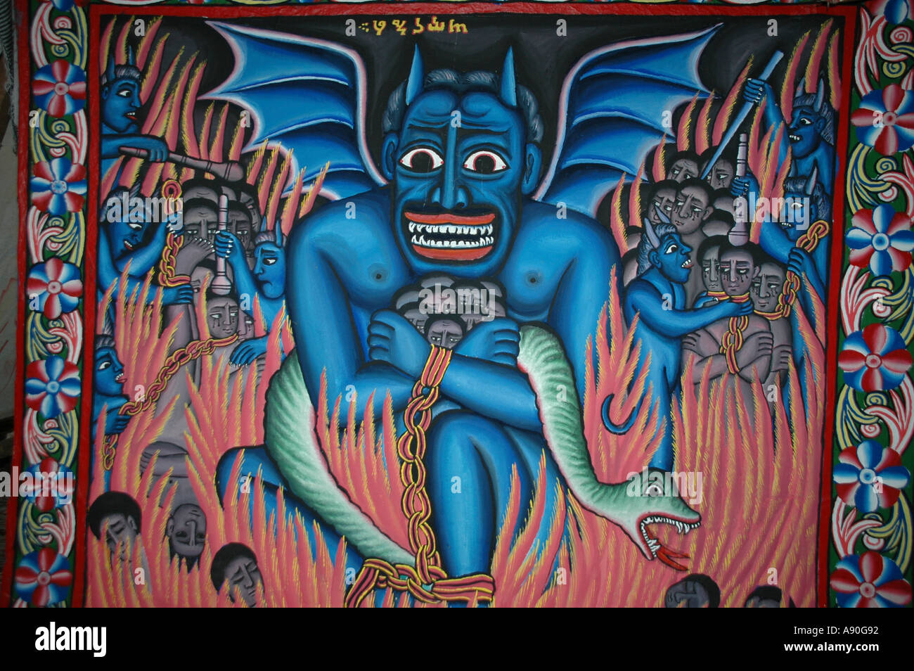 Wall painting blue coloured devil with sinners Stock Photo - Alamy