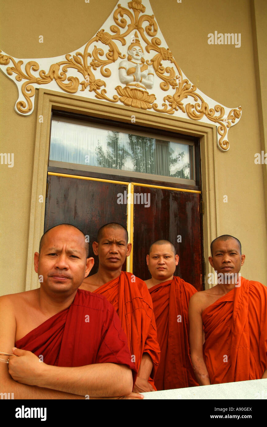 Four monks pose for a picture outside their temple Stock Photo - Alamy