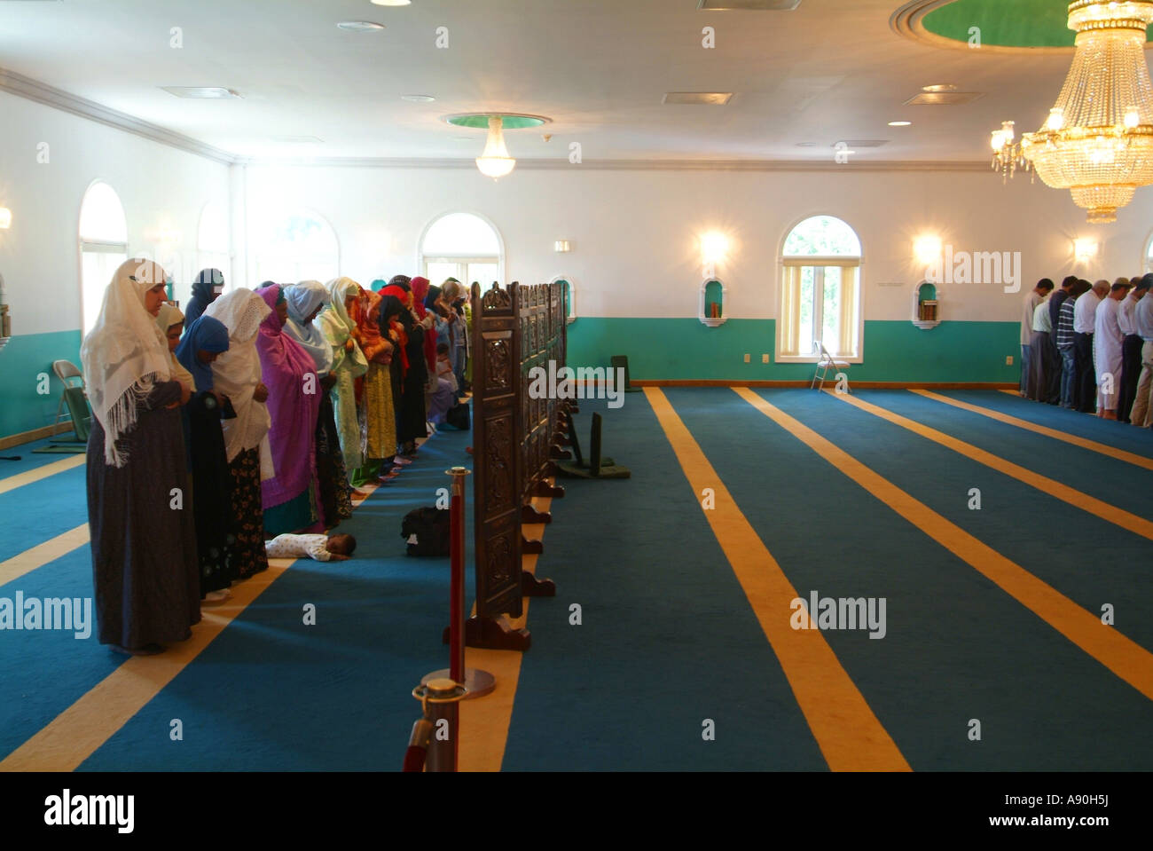 Men and women are separated in the mosque by a wooden screen A baby ...