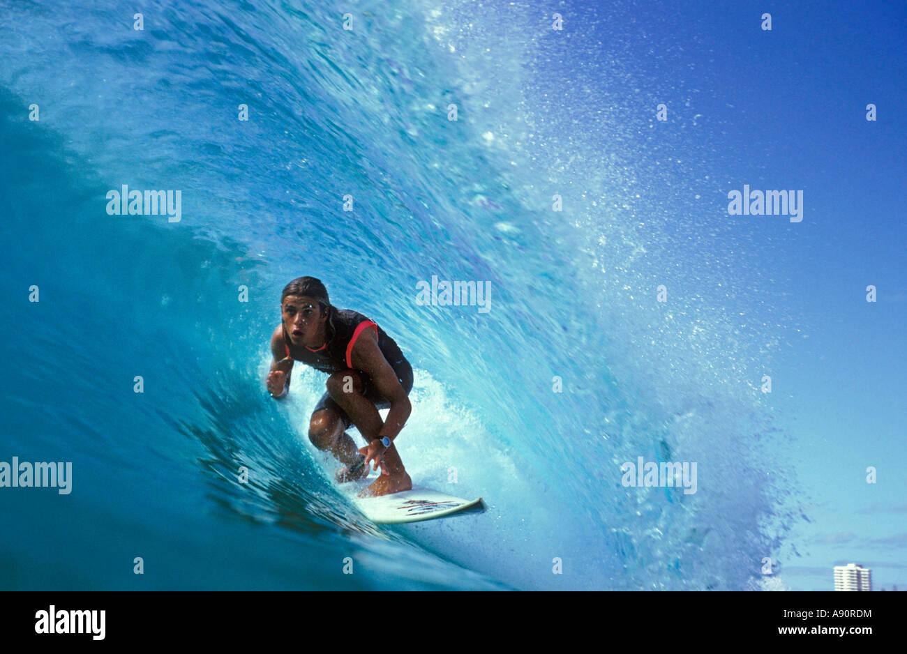 Young male surfer crouching on his surfboard in a tube Stock Photo - Alamy