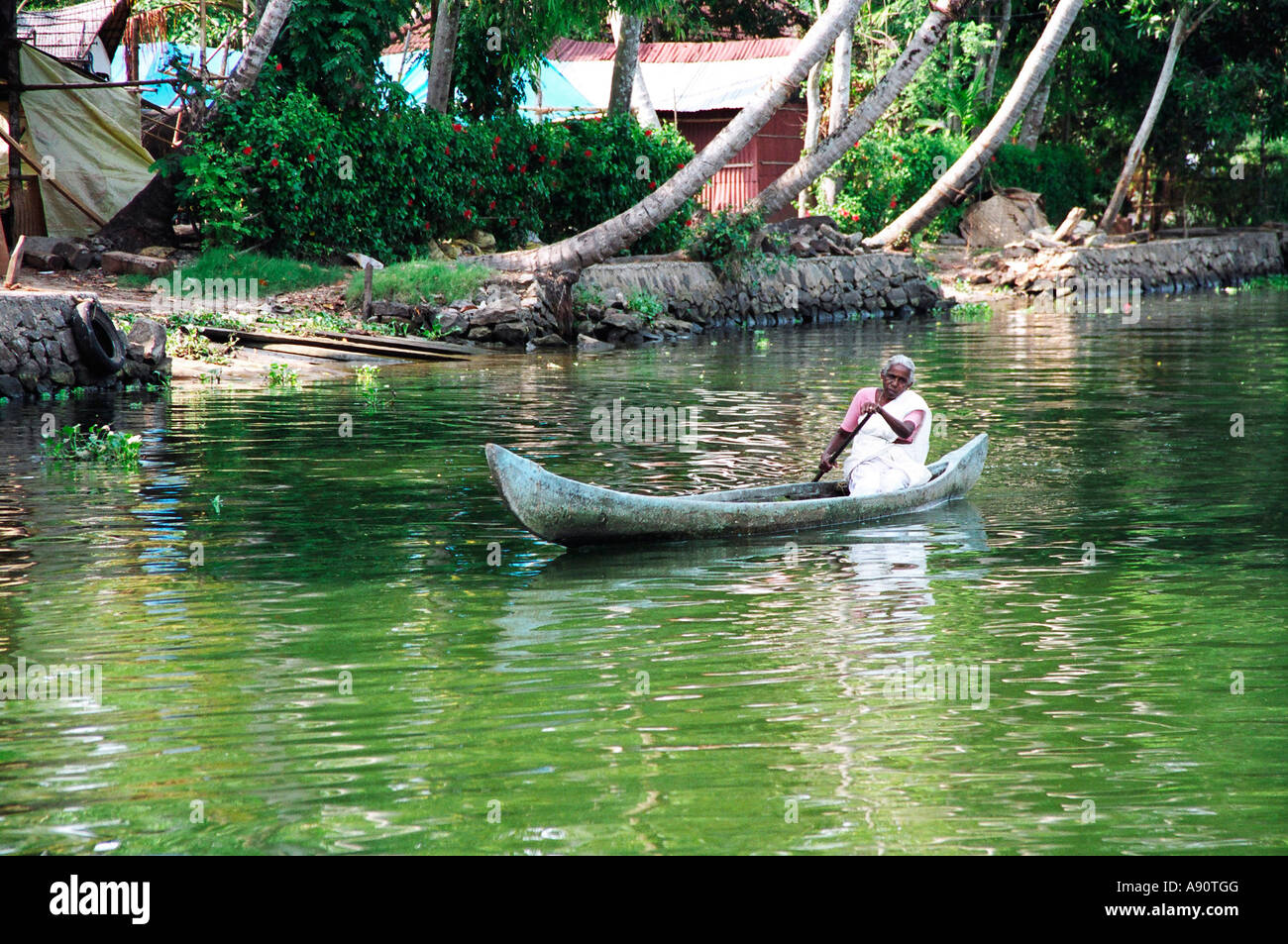 A local woman in Kerala rowing her boat on the backwaters Stock Photo ...