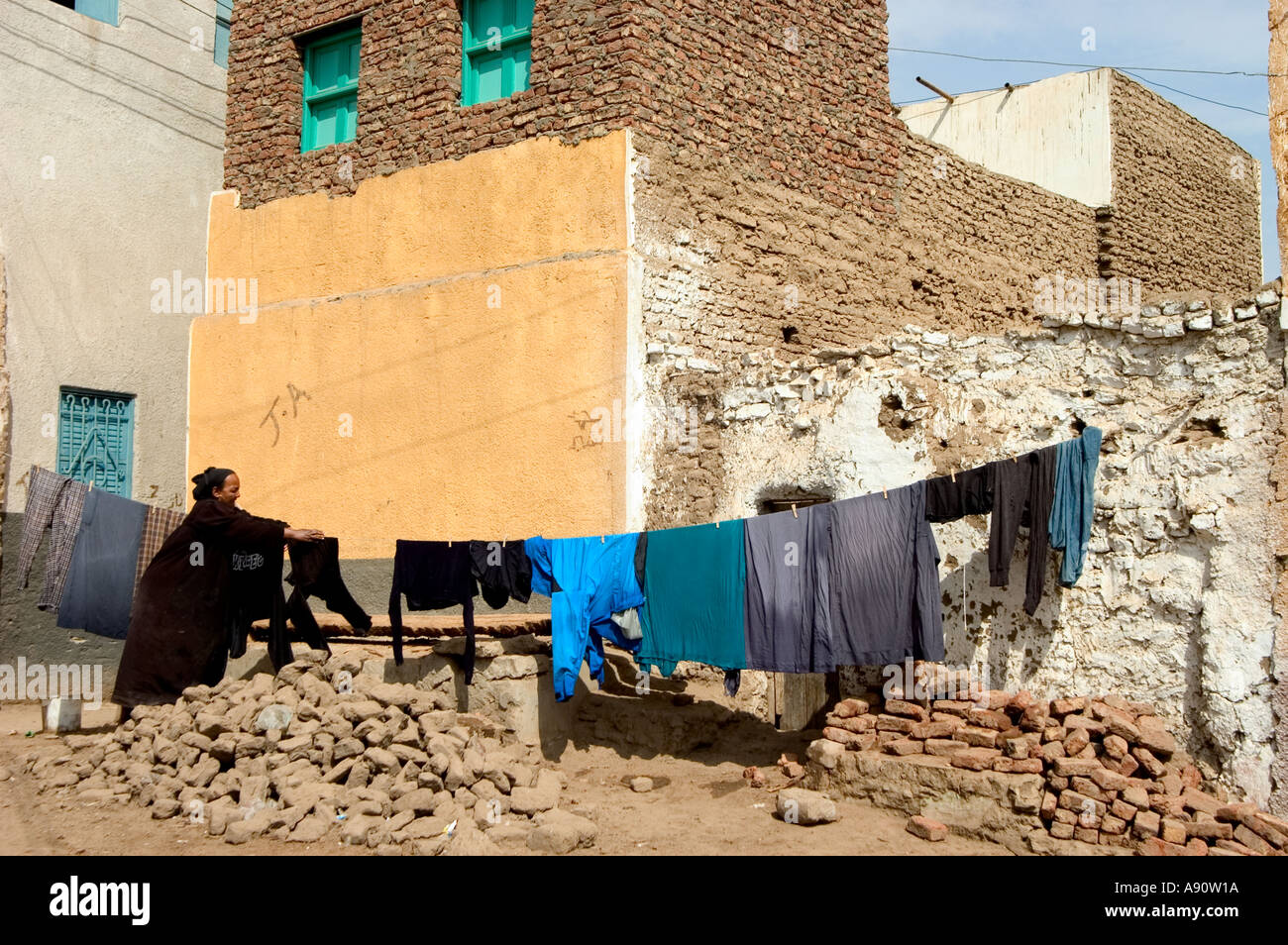 woman hanging drying washing Elephantine Island Aswan Upper Egypt Egypt ...