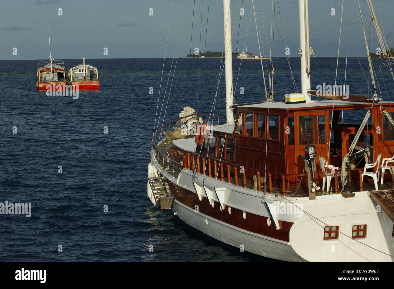 A Sailboat Facing Two Red Boats At Male City Port Stock Photo - Alamy