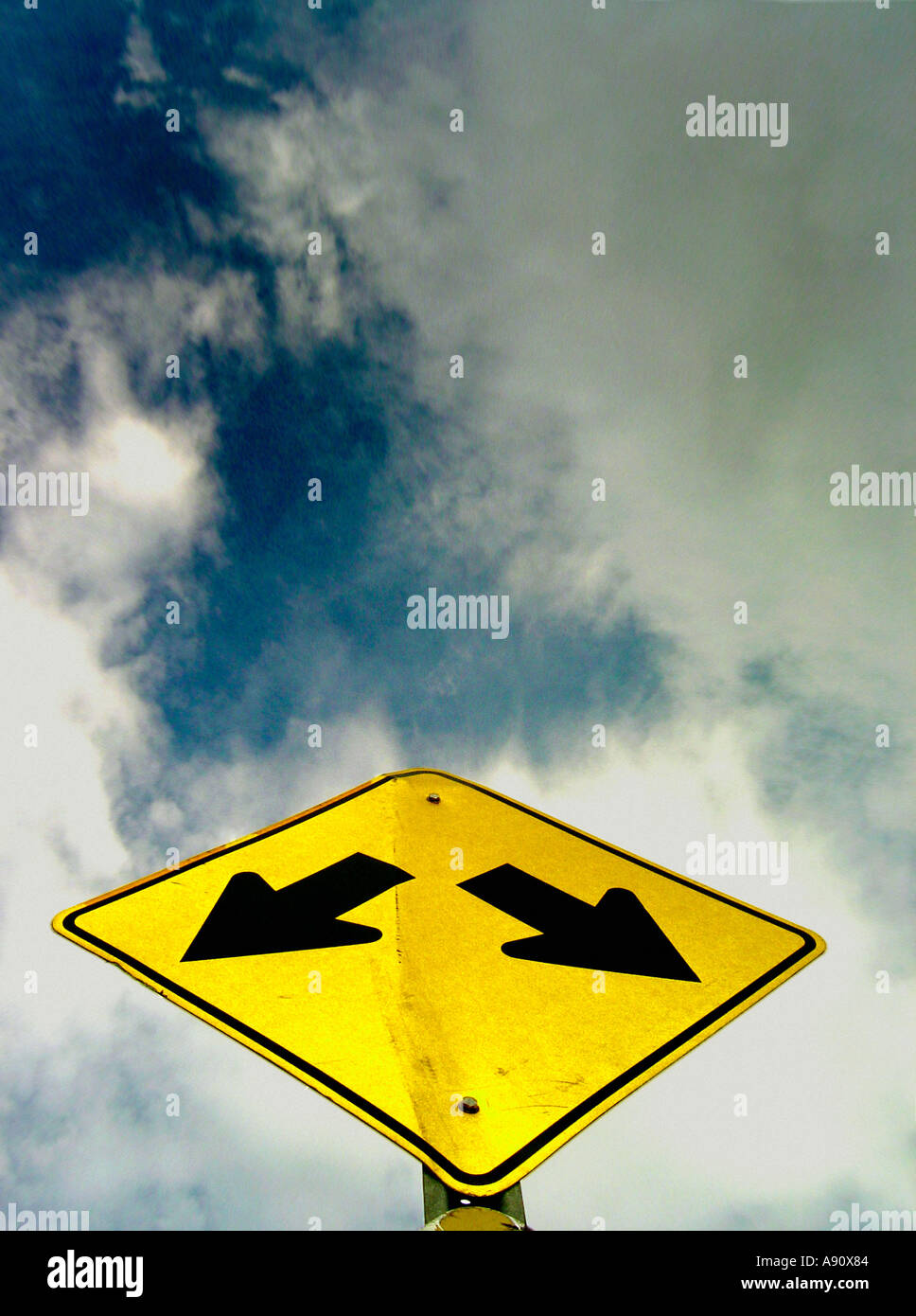 Urban Scene of Yellow Road Sign With Two Black Arrows Pointing Downward ...