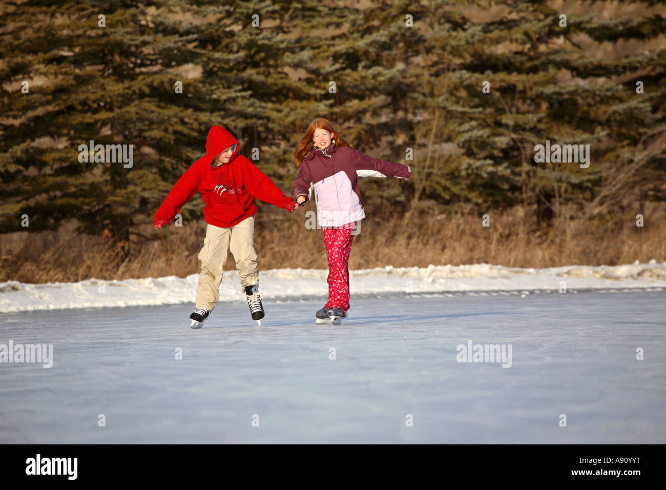 Boy and girl children ice skating hi-res stock photography and images ...