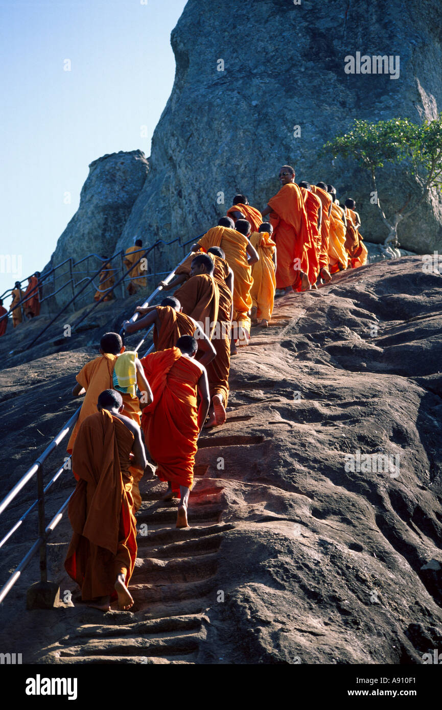 A file of monks climbing up a mountain on a pilgrimage in Sri Lanka ...
