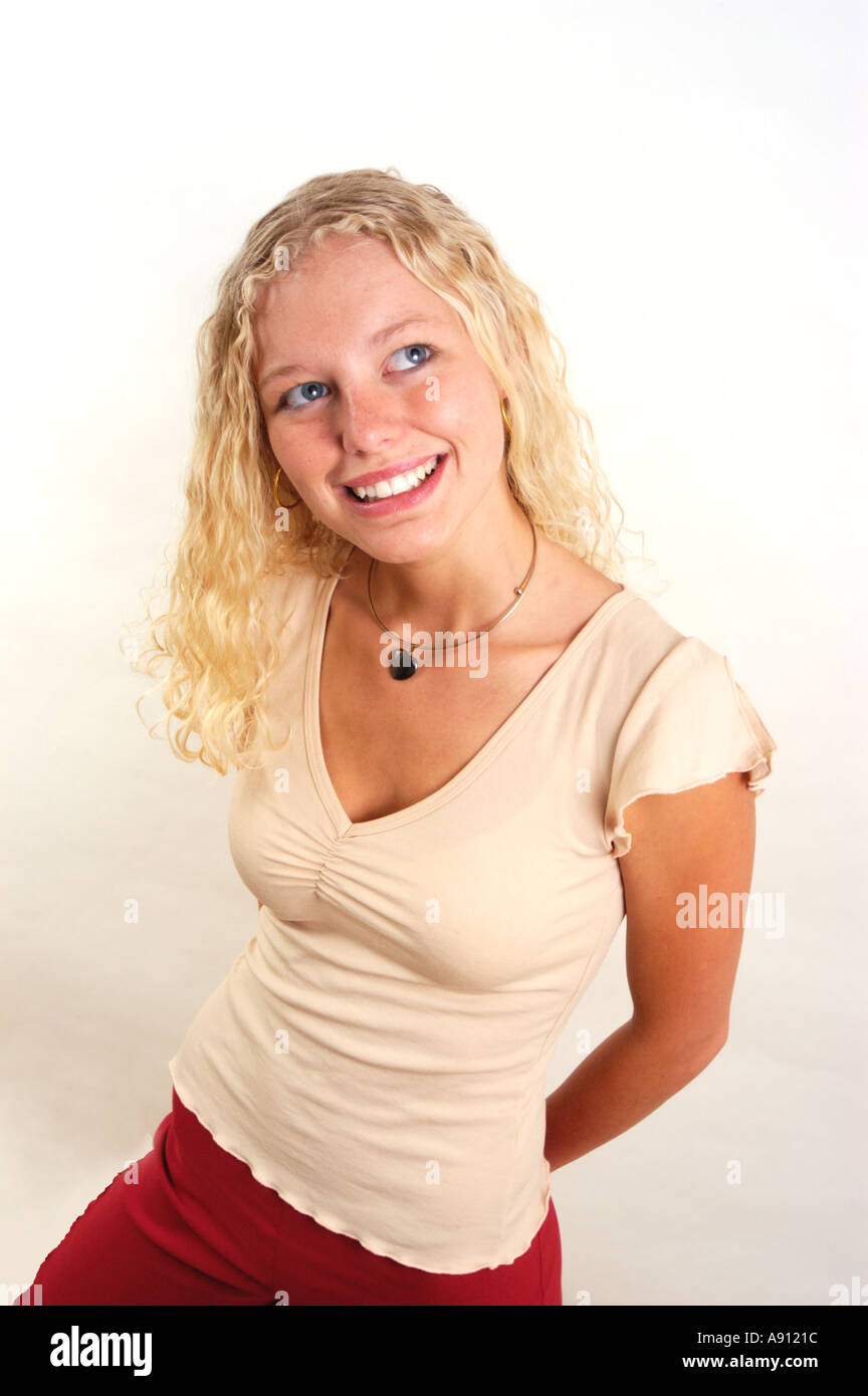 Young woman smiling with arm behind back Stock Photo - Alamy