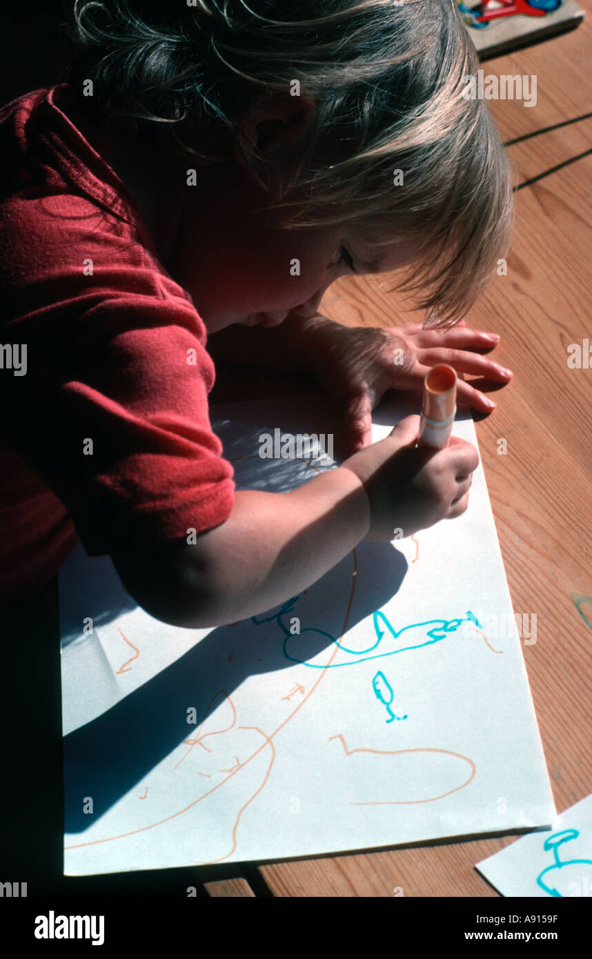 Small girl drawing a picture with great concentration Stock Photo - Alamy