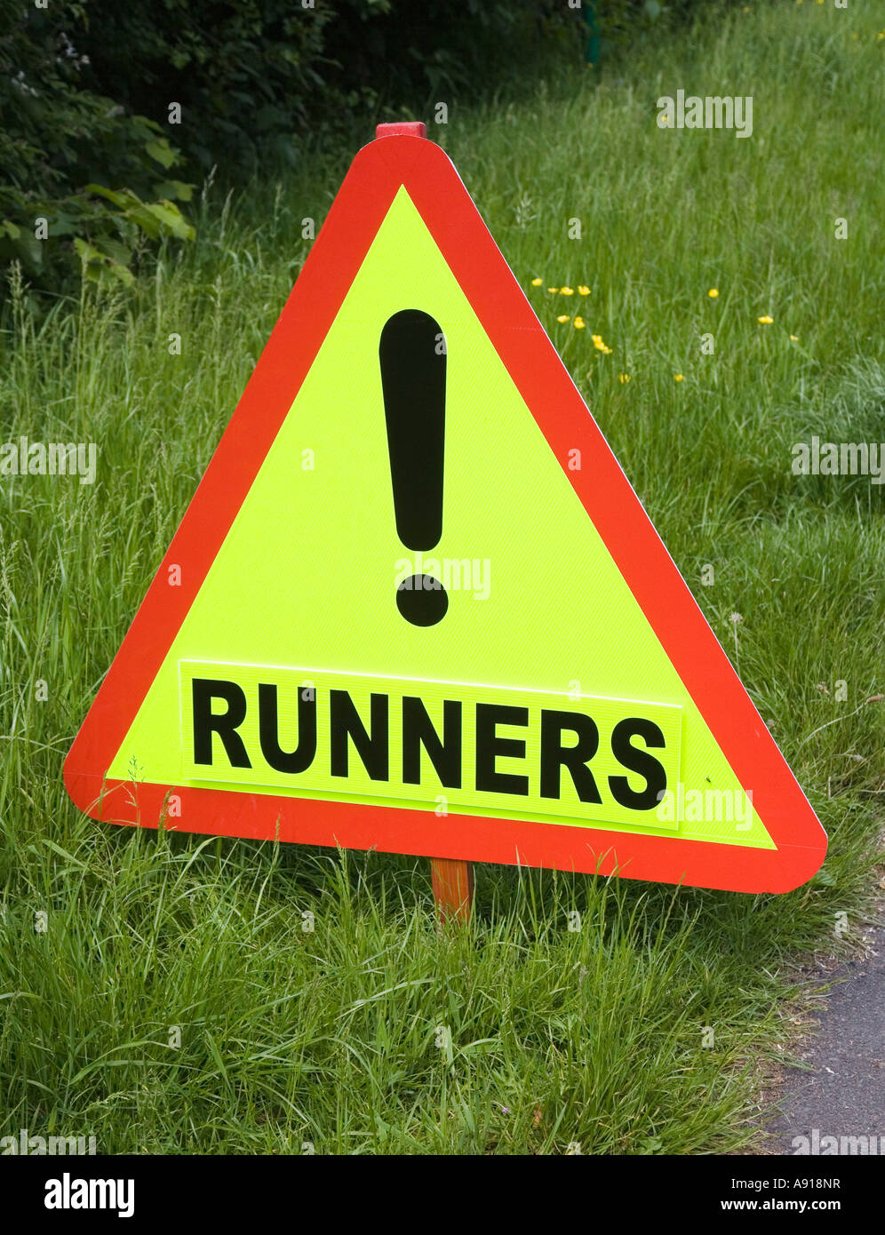 Red triangle warning sign of runners in road race Wales UK Stock Photo ...