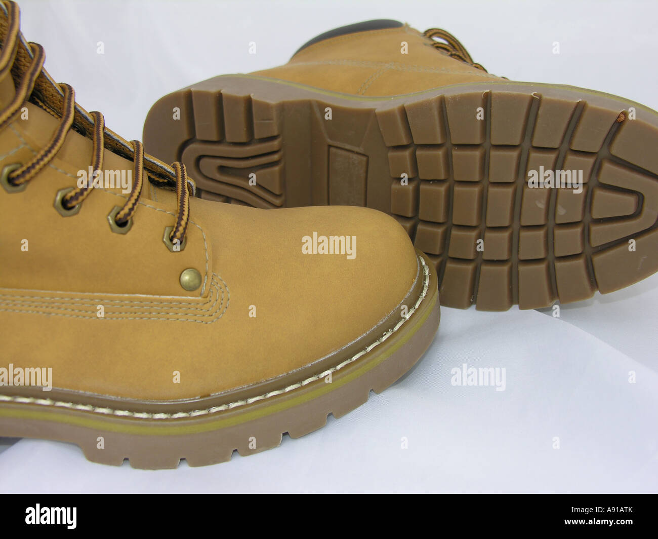 A pair of tan boots on a white background Stock Photo - Alamy