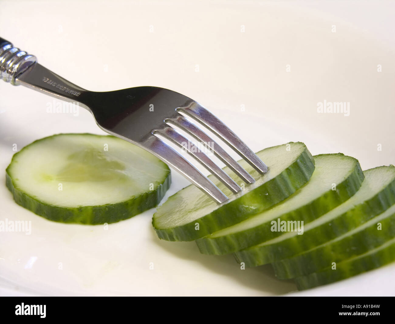 A fork picking up several slices of cucumber Stock Photo - Alamy