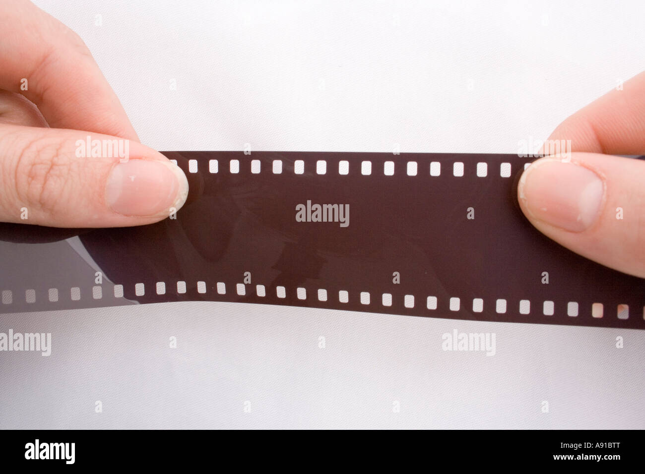 Two hands holding a roll of film negatives, trying to tear it apart ...