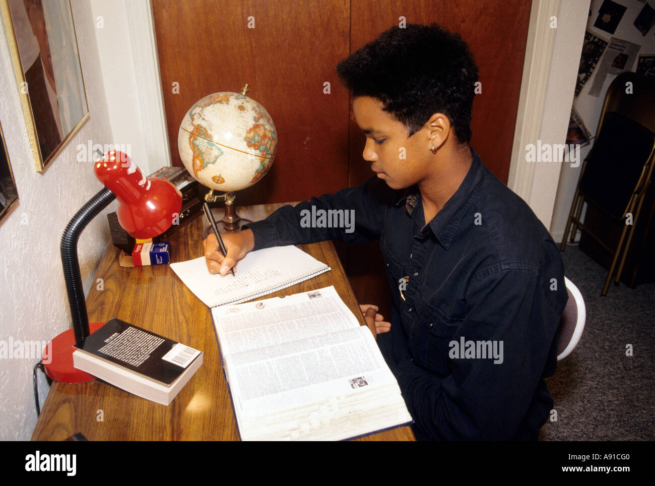 Fifteen year old african american boy doing homework and studying at ...