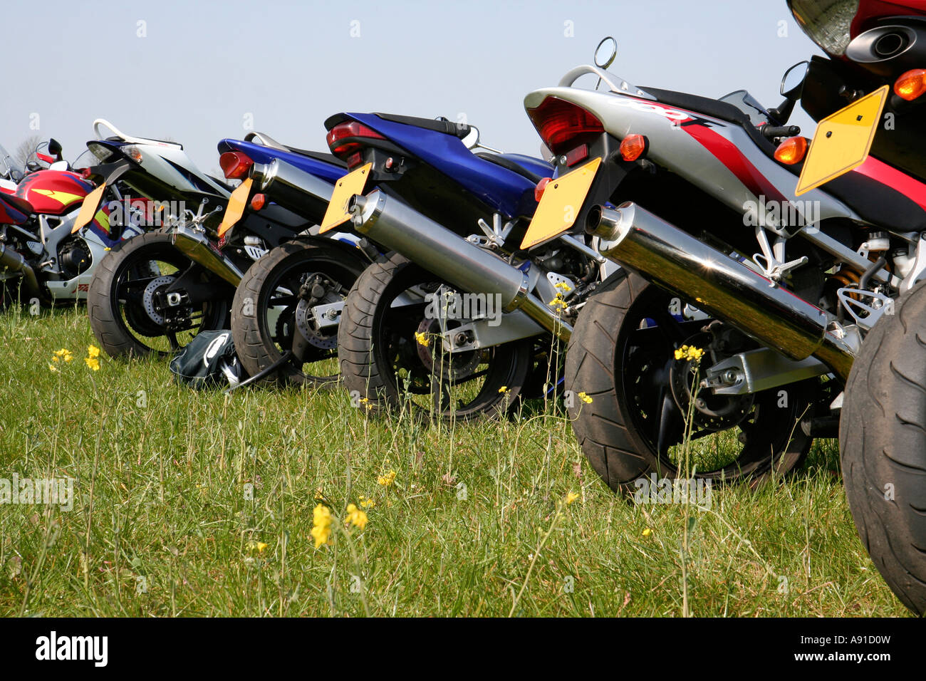 The rear of a line of motorbikes in a field Stock Photo - Alamy