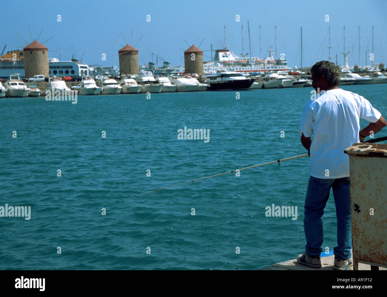Local man fishing in the harbor Rhodes Greece Stock Photo - Alamy