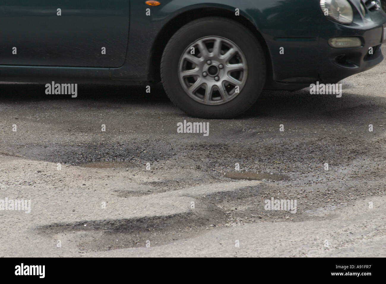 car driving by dangerous potholes on a road. concept danger, hazard ...