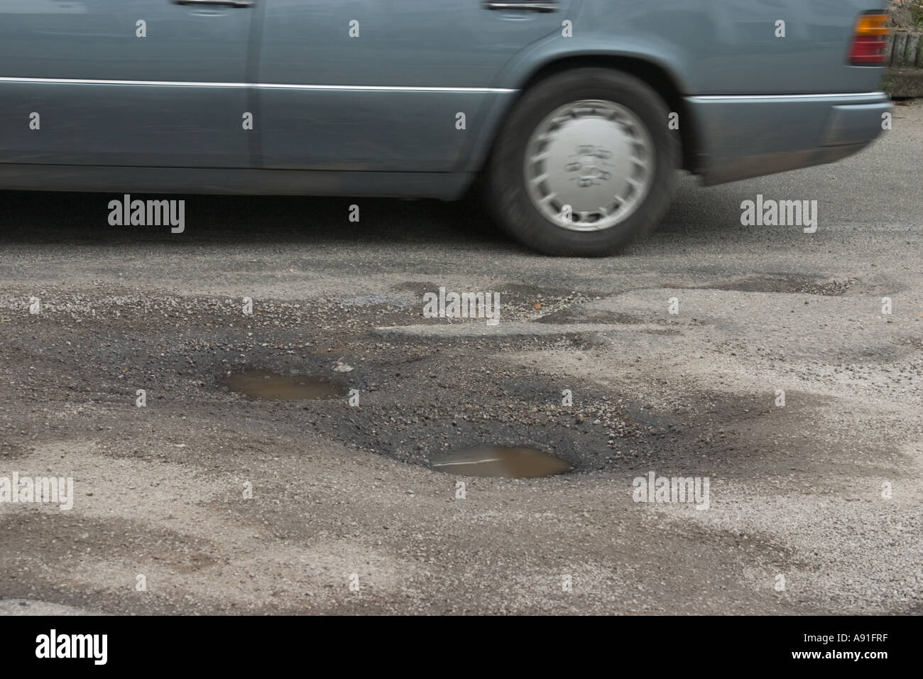 car driving by dangerous potholes on a road. concept danger, hazard ...
