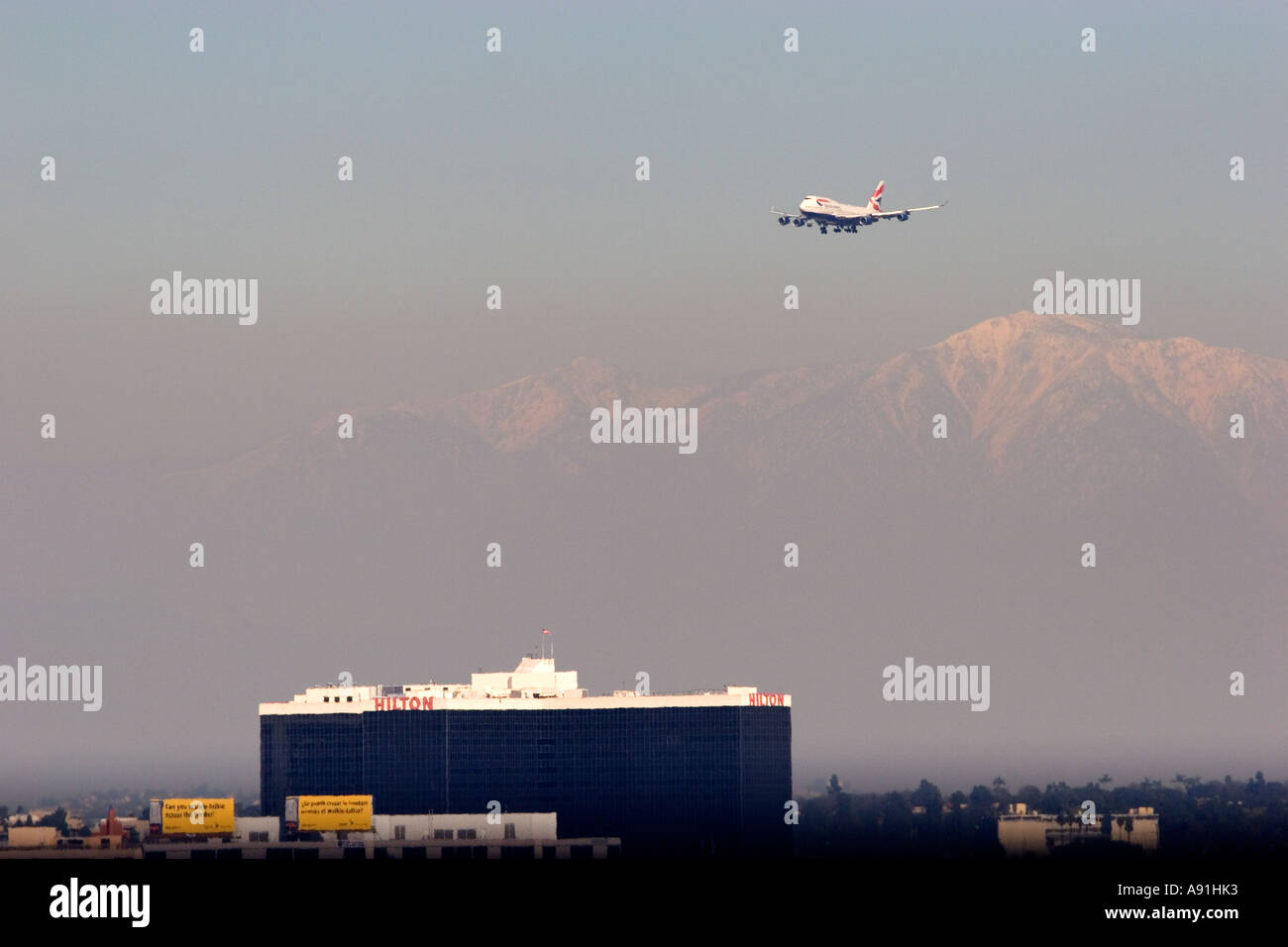 Boeing 747 airliner landing at LAX with snow covered mountains in ...