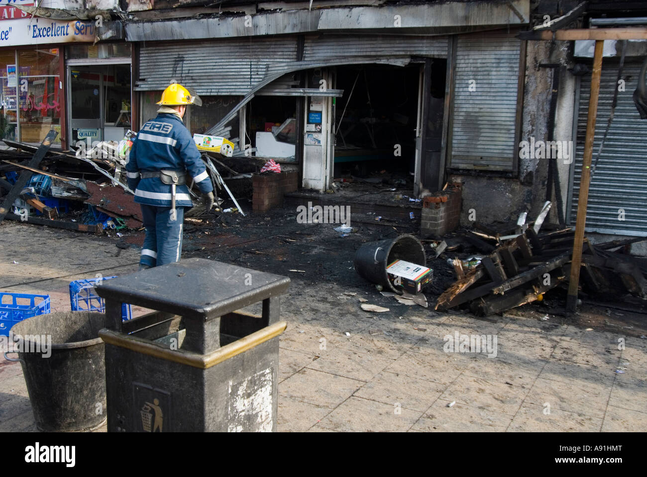 Firefighter next to burnt store Stock Photo - Alamy